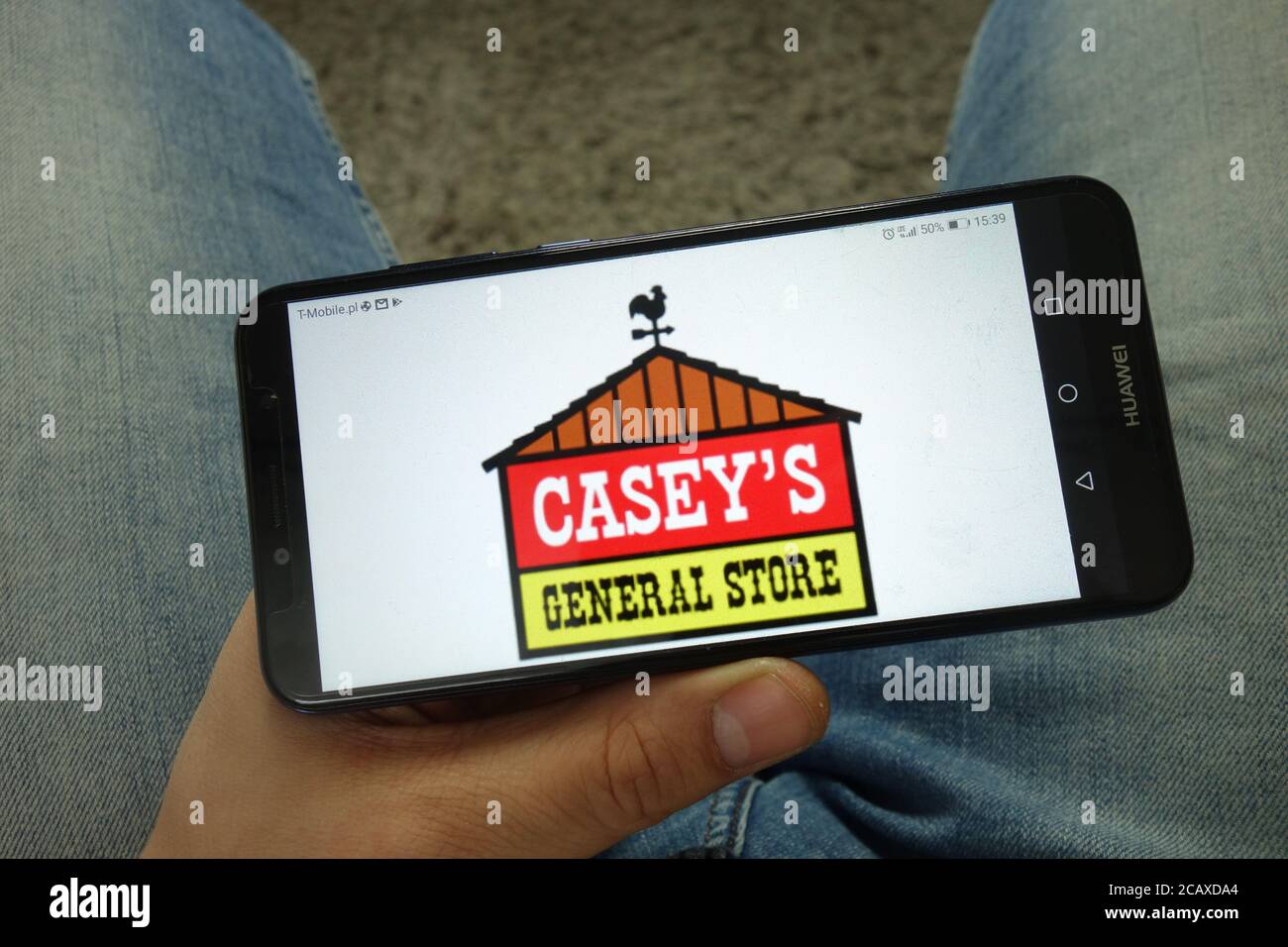 Man holding smartphone with Casey`s General Stores, Inc. logo Stock Photo - Alamy